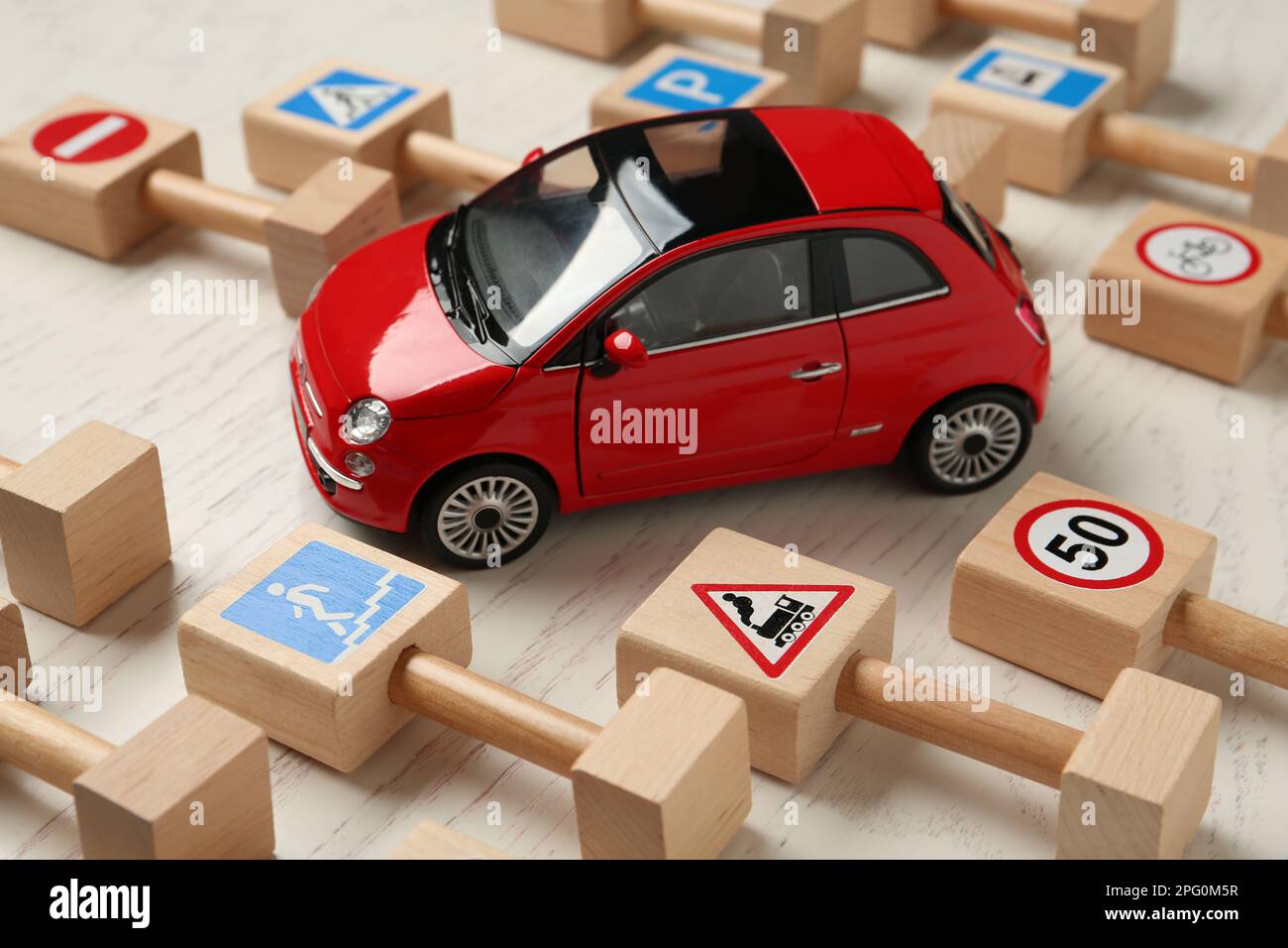 Many different miniature road signs and car on white wooden table ...