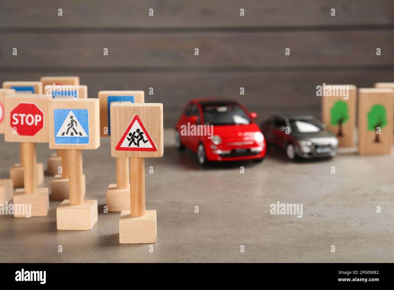 Many different miniature road signs and cars on grey table, space for ...