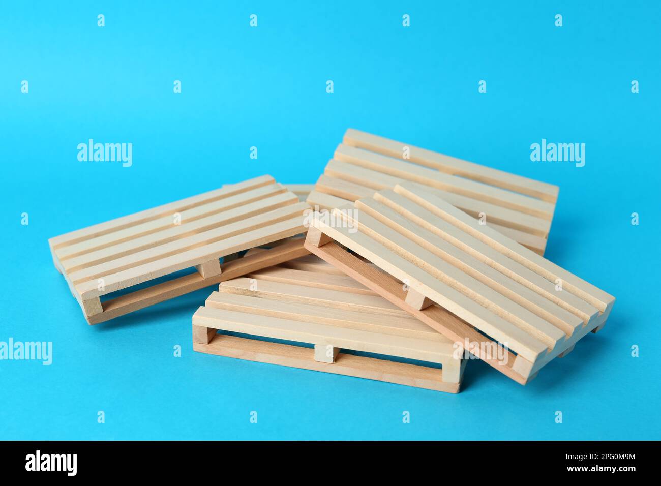 Pile of wooden pallets on light blue background Stock Photo - Alamy