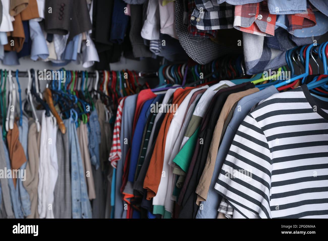 Hangers with stylish clothes on racks as background, closeup. Fast ...