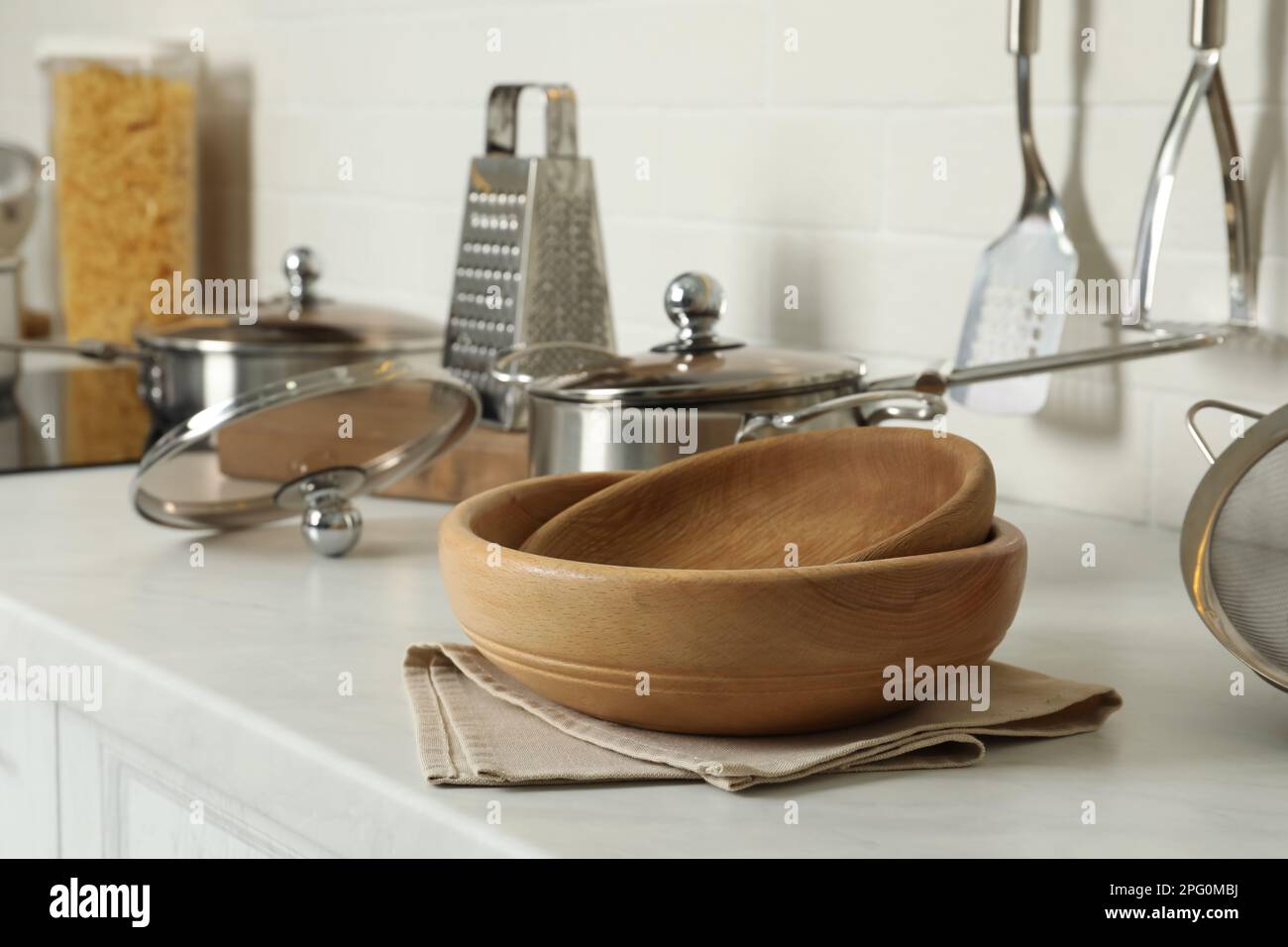 Wooden bowls and different cooking utensils on kitchen counter Stock ...