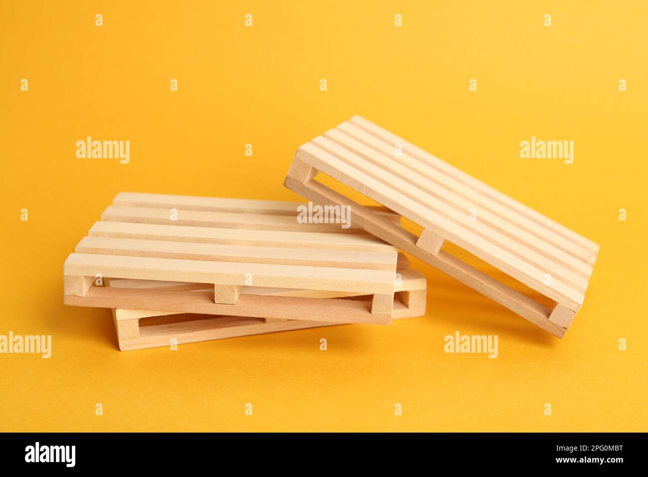 Three small wooden pallets on orange background Stock Photo - Alamy