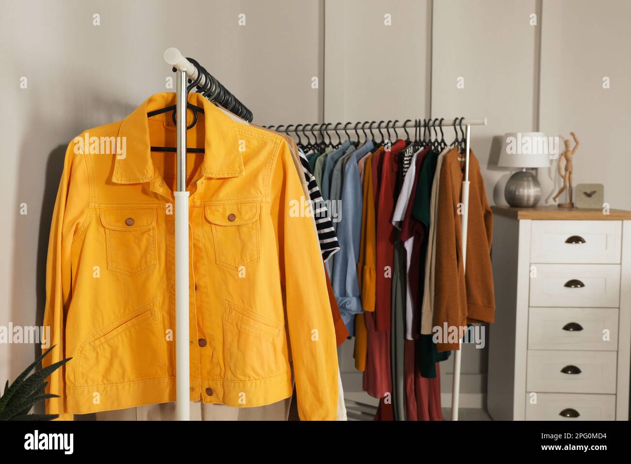 Racks with stylish clothes indoors. Fast fashion Stock Photo - Alamy
