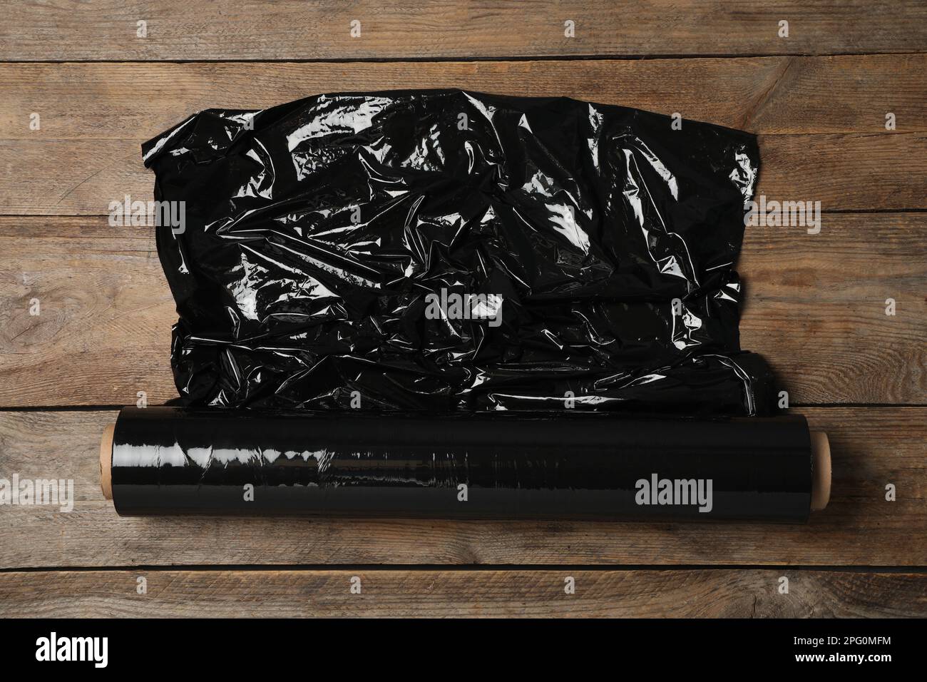 Roll of plastic stretch wrap film on wooden table, top view Stock Photo ...