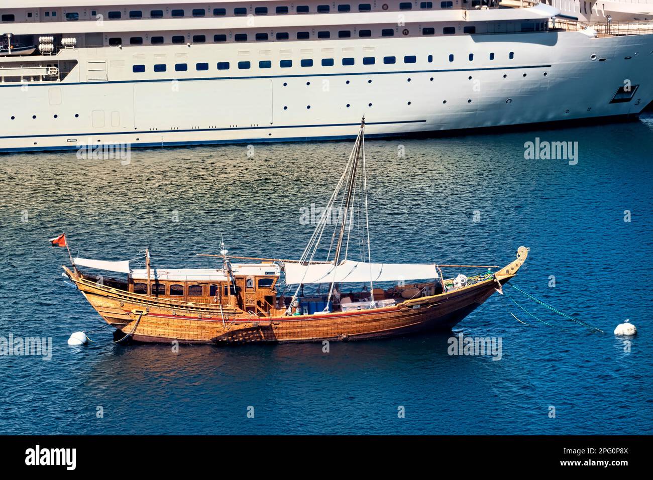 Cruise ship and traditional dhow in the Mutrah Harbor, Muscat, Oman ...