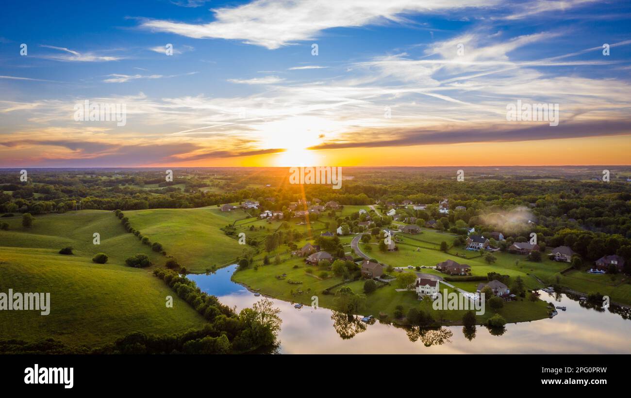 Scenic aerial view of sunset over rural neighborhood and a lake in ...