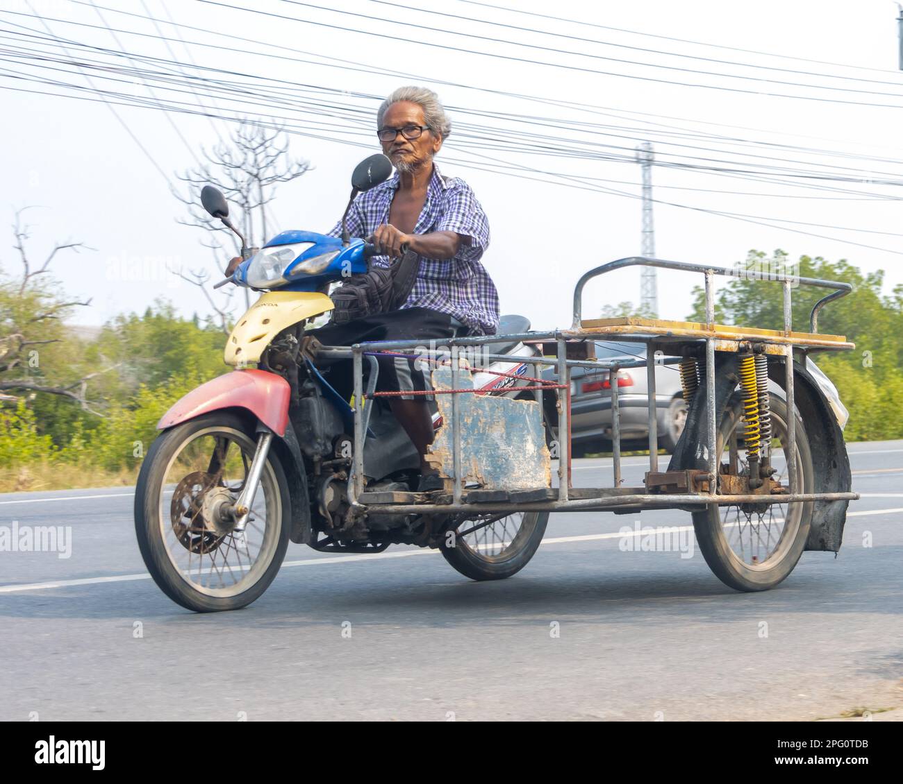 BANGKOK, THAILAND, MAR 11 2023, A elderly man drives a motorcycle with ...
