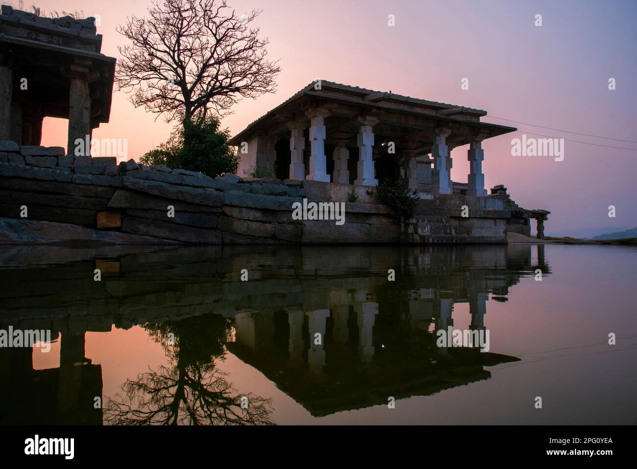 Ruins of old temples with reflection in a pond on Hemakuta Hill in ...