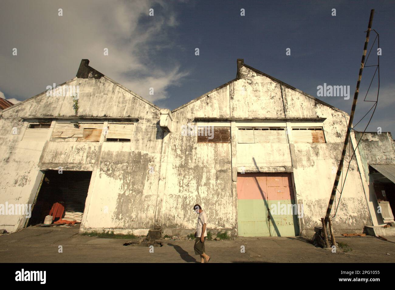 A man is walking on a road in seaport area, in a background of a ...