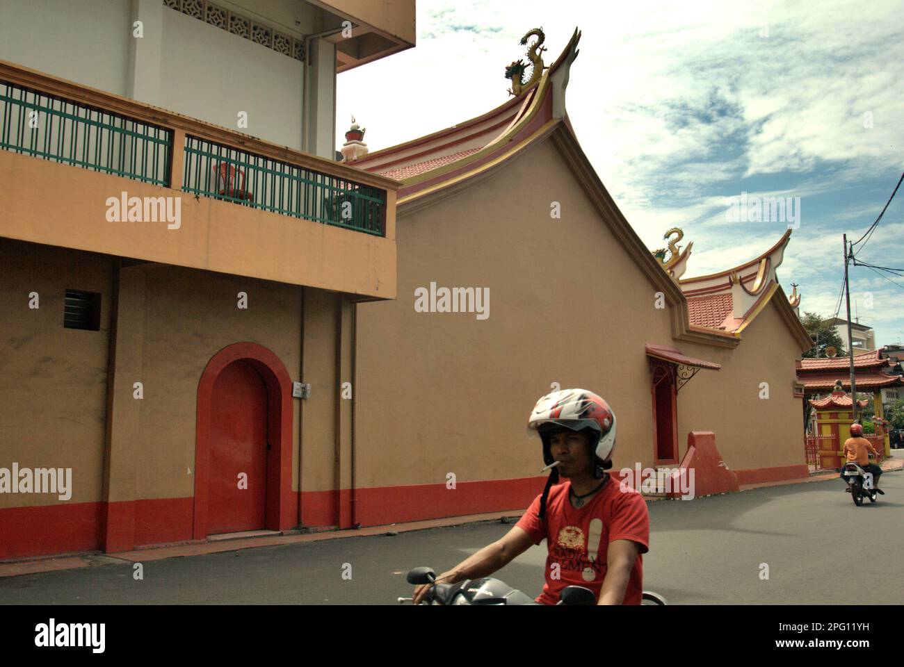A motorist is photographed as he is riding down a street in chinatown ...