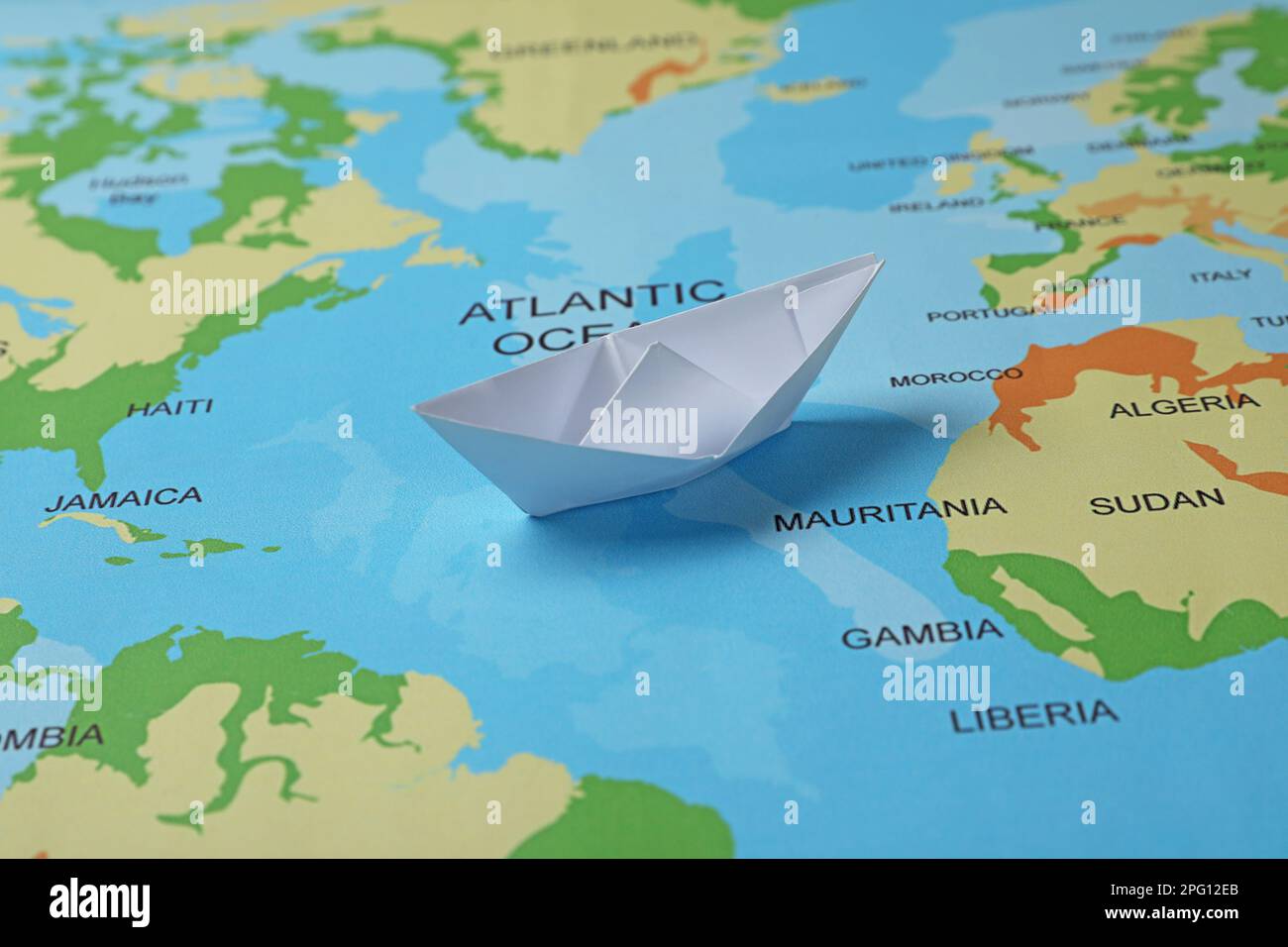 One white paper boat on world map Stock Photo - Alamy