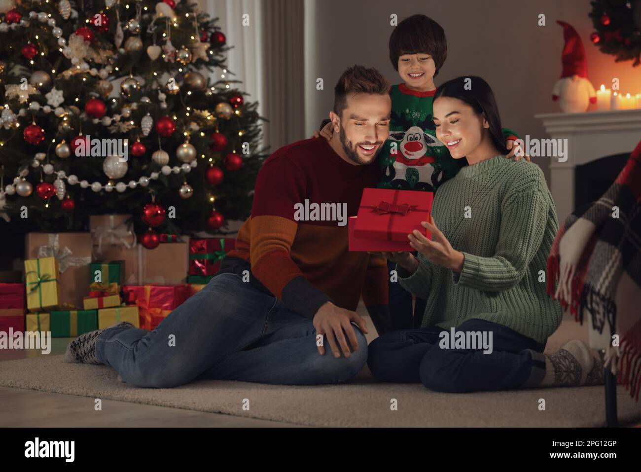 Happy family opening gift box with magical light at home. Christmas ...