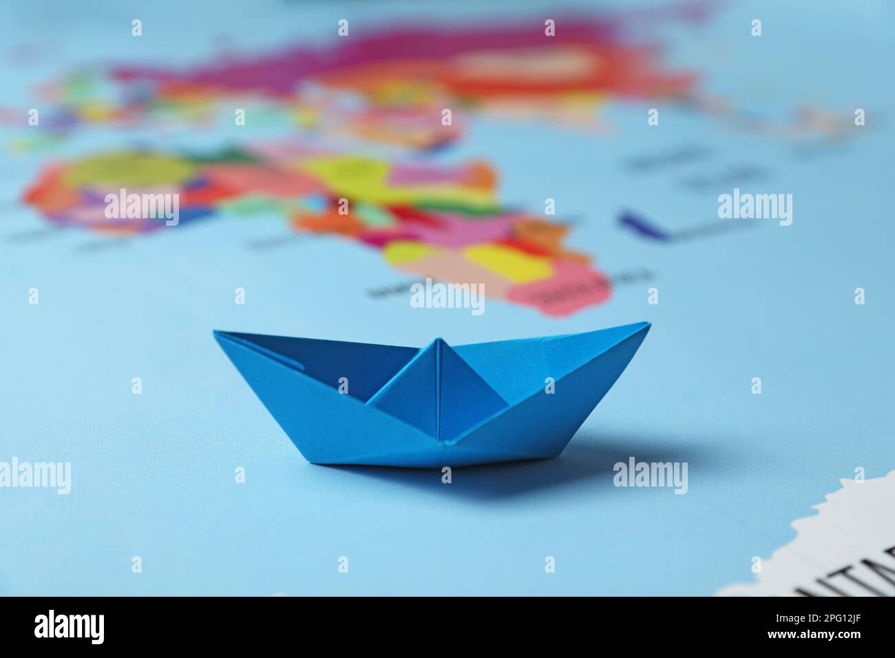 Light blue paper boat on world map, closeup Stock Photo - Alamy