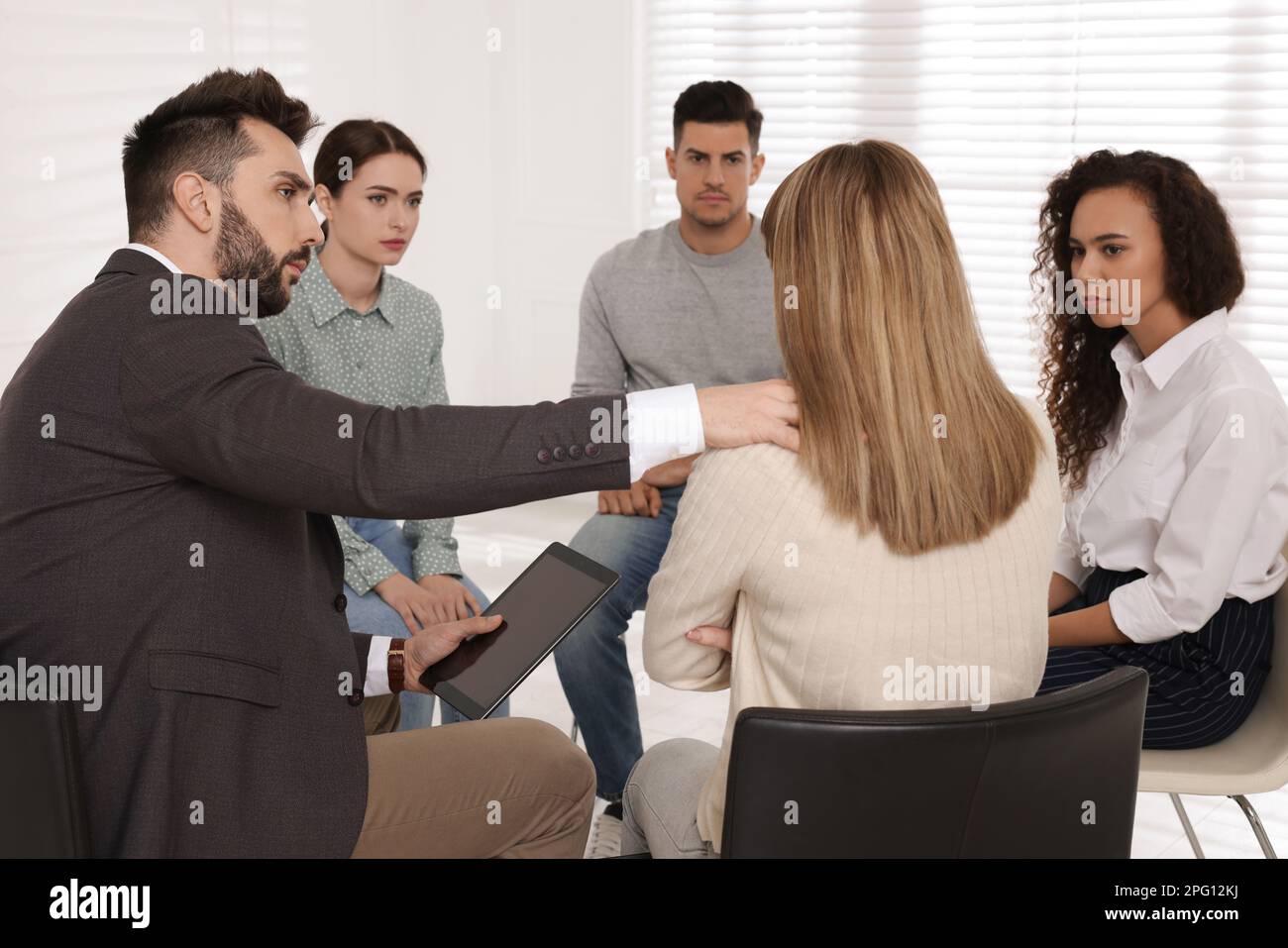 Psychotherapist working with patients at group session indoors Stock ...