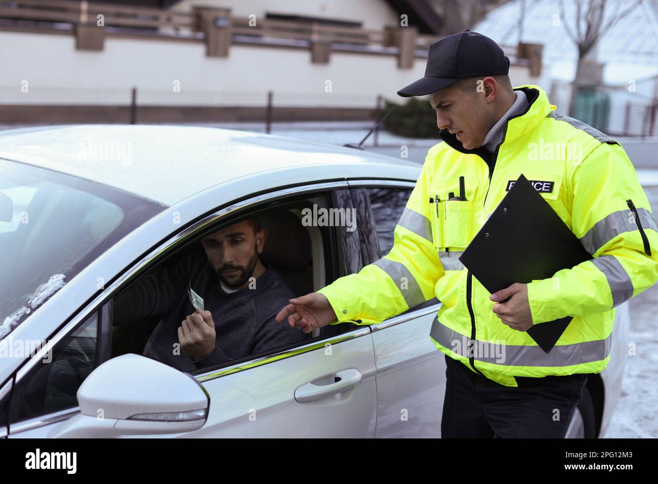 Man giving bribe to police officer out of car window outdoors Stock ...