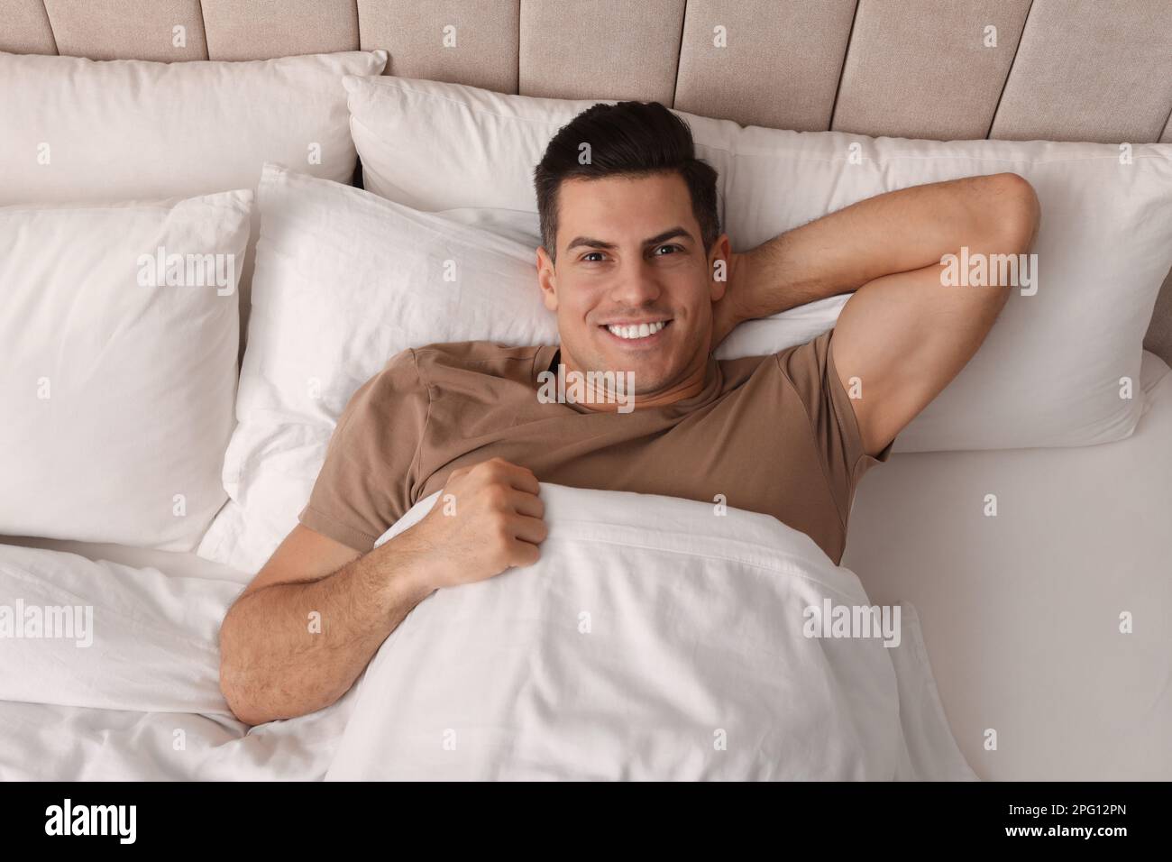 Happy man lying in bed at home, top view Stock Photo - Alamy