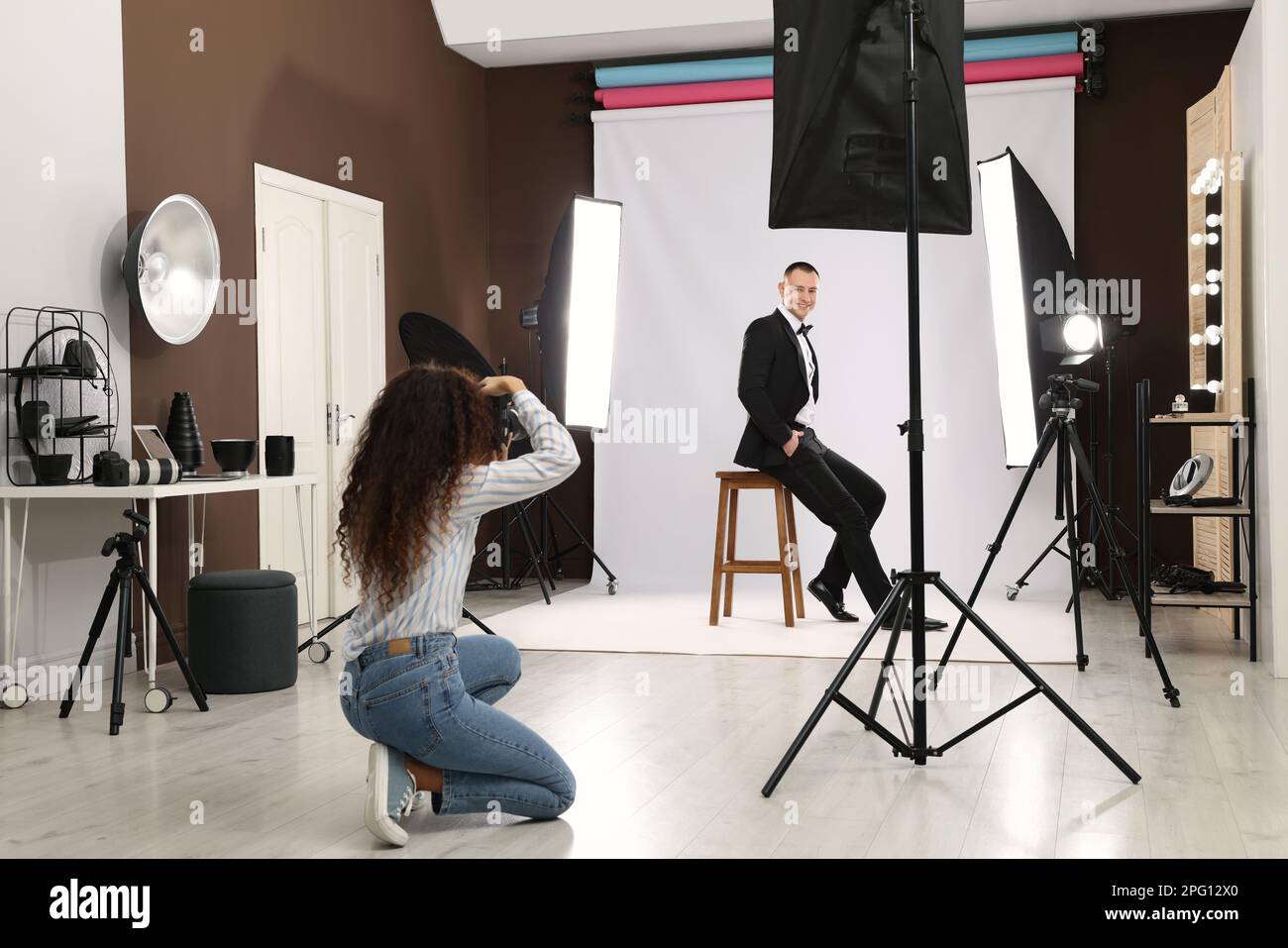 Handsome model posing for professional photographer in studio Stock ...