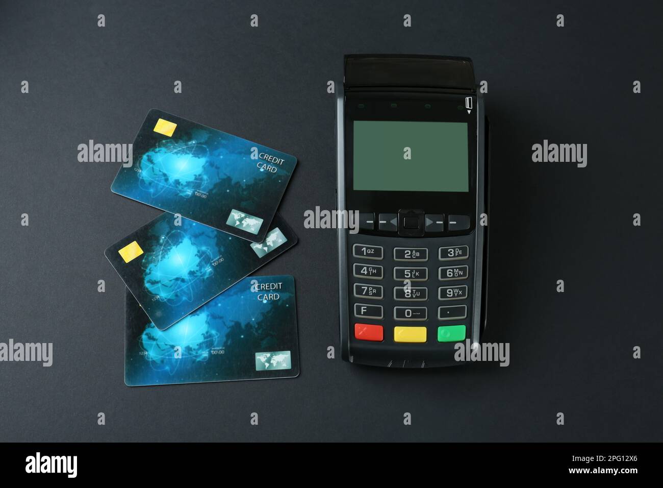 New modern payment terminal and credit cards on black background, flat ...