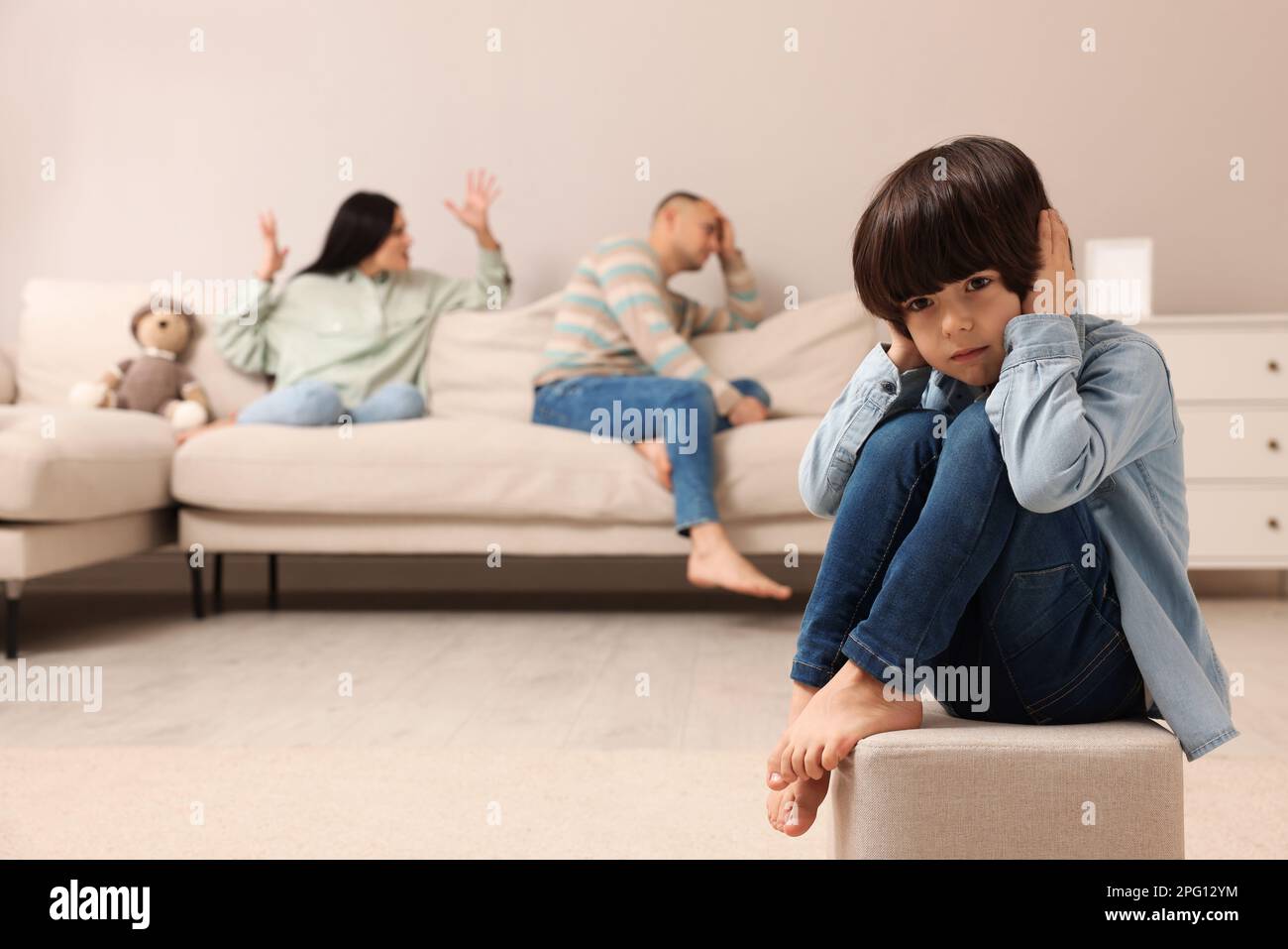 Couple arguing at home, focus on their upset child Stock Photo - Alamy