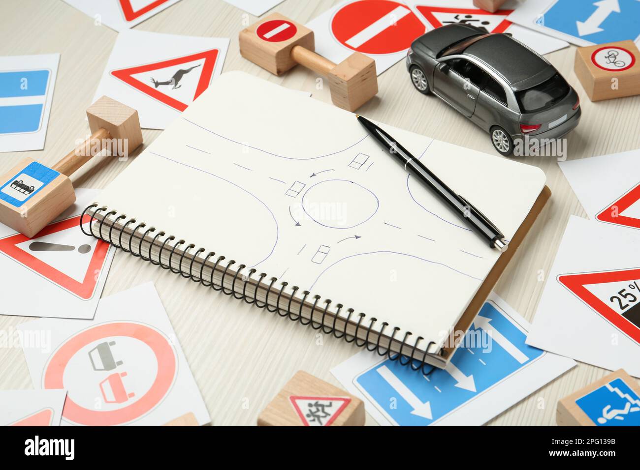 Many different road signs, notebook with sketch of roundabout and toy ...