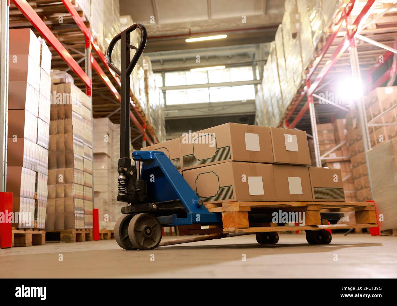 Manual forklift with cardboard boxes in warehouse. Logistics concept ...