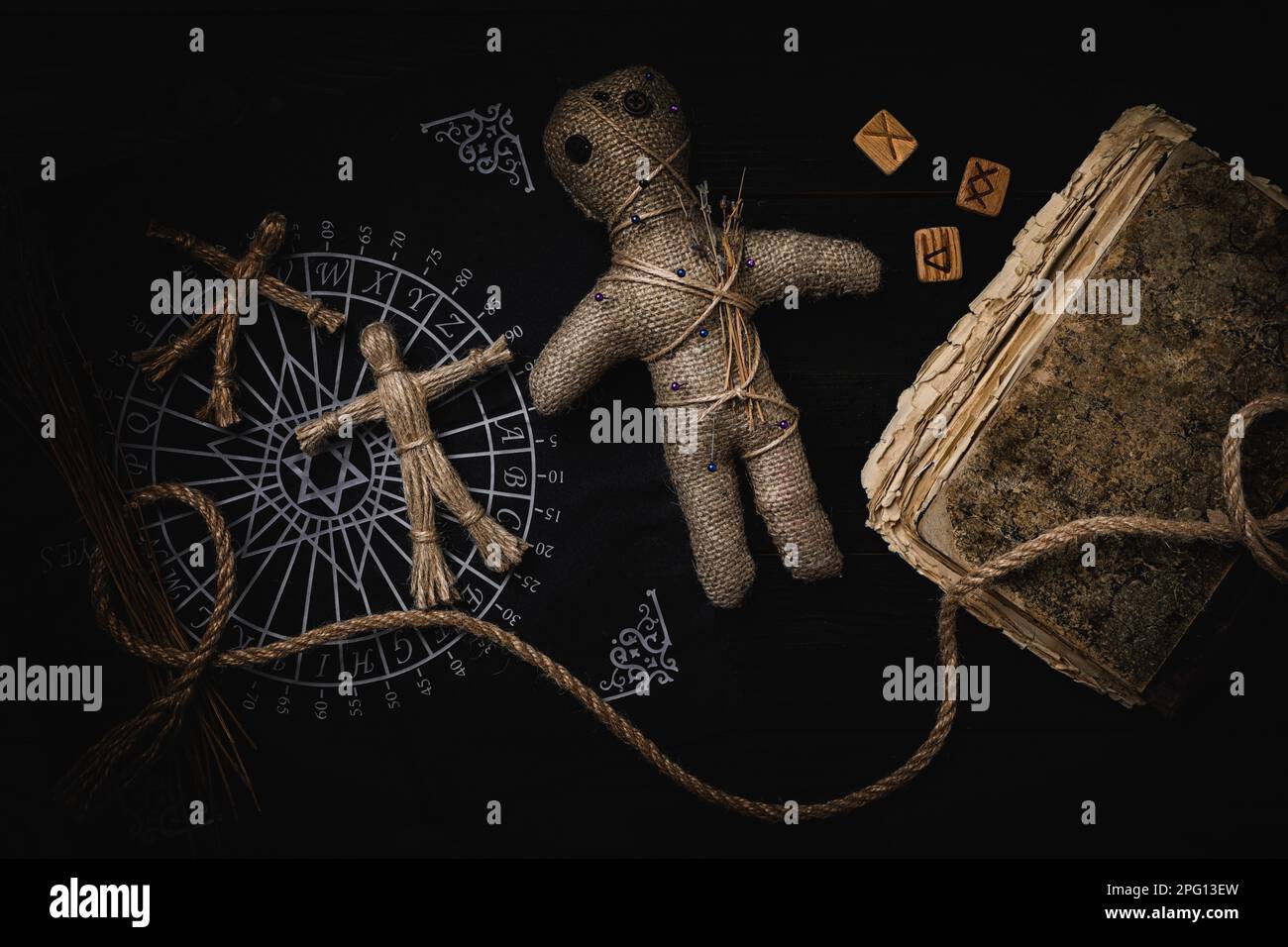 Voodoo doll with pins surrounded by ceremonial items on table, flat lay ...