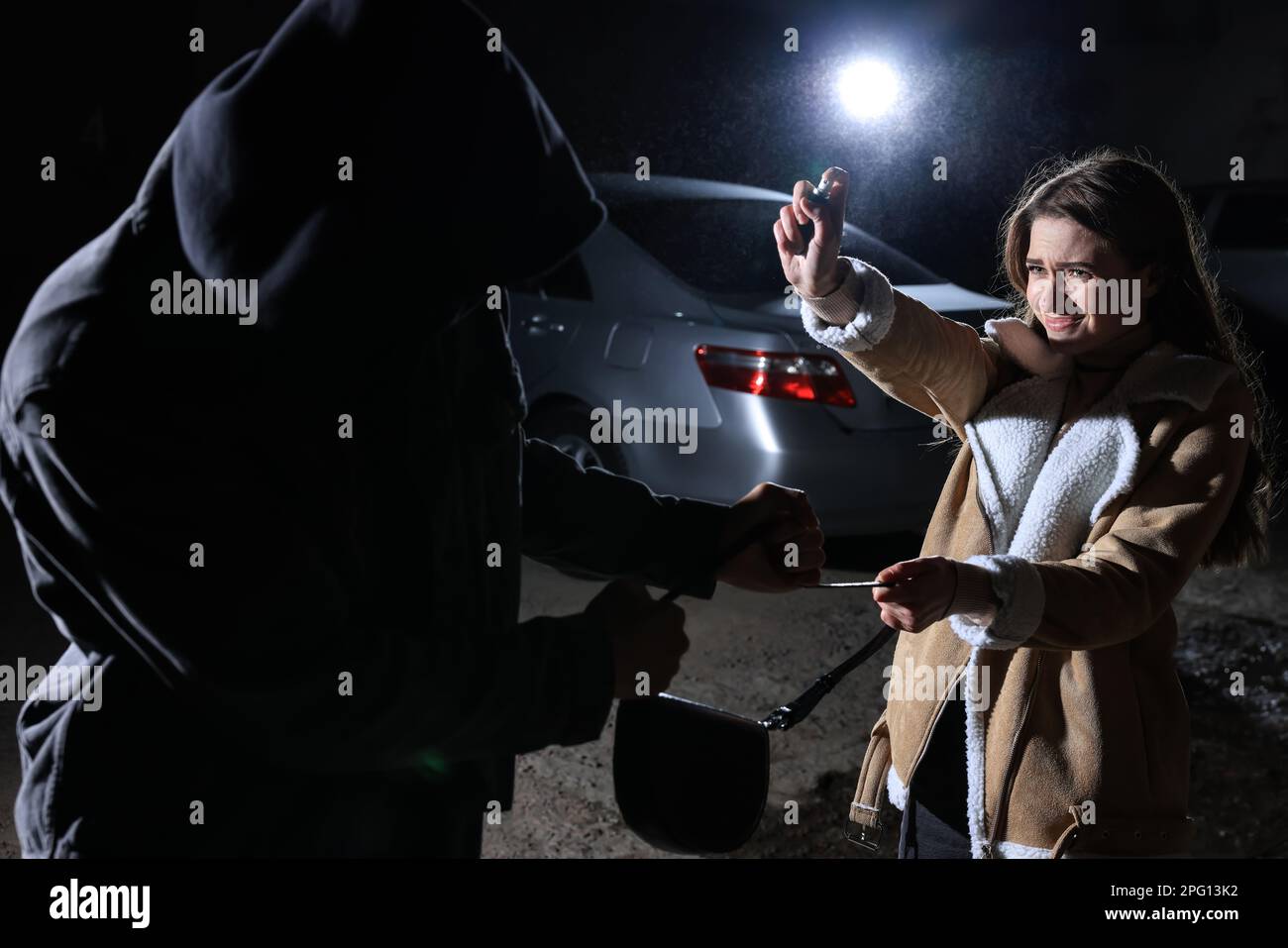Woman using pepper spray while thief trying to steal her bag outdoors ...