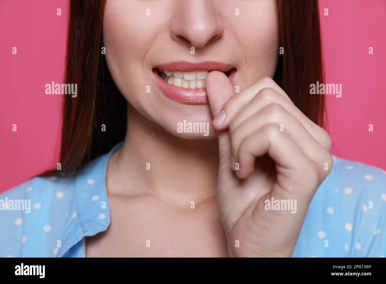 Young woman biting her nails on pink background, closeup Stock Photo ...