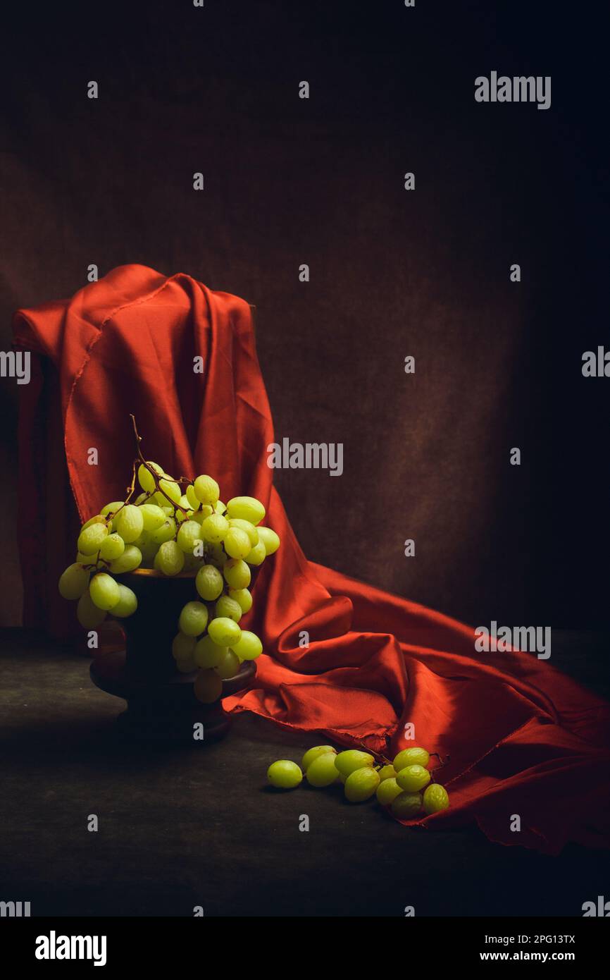 Still life with grapes and red cloth Stock Photo - Alamy