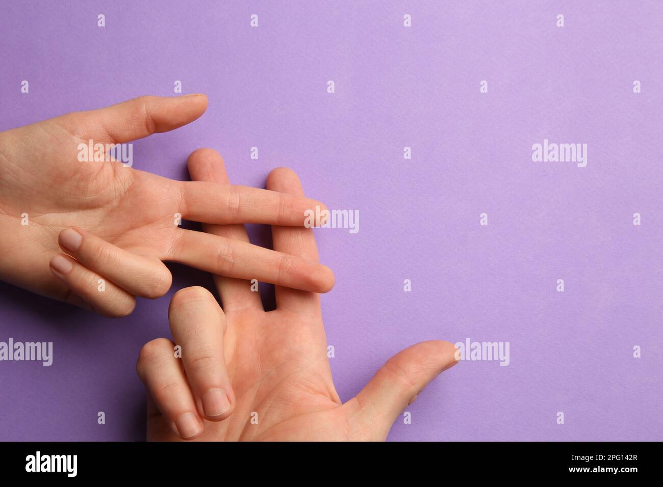 Man and woman making hashtag symbol with their hands on violet ...