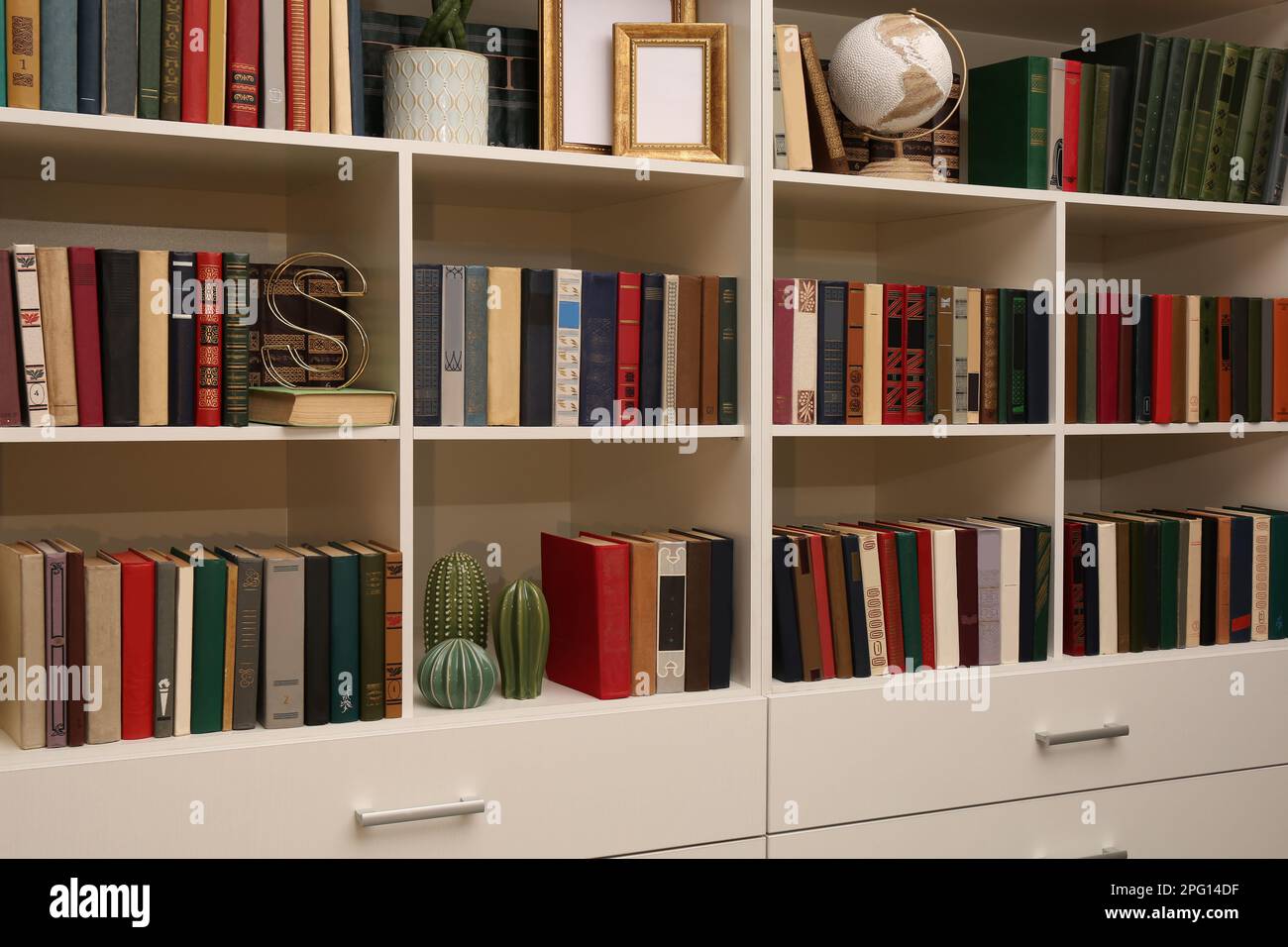 Collection of different books and decorative elements on shelves in ...