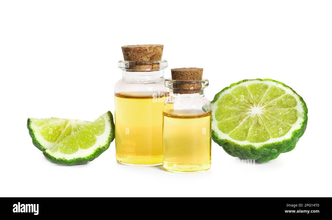 Bottles of essential oil and fresh bergamot fruit on white background ...