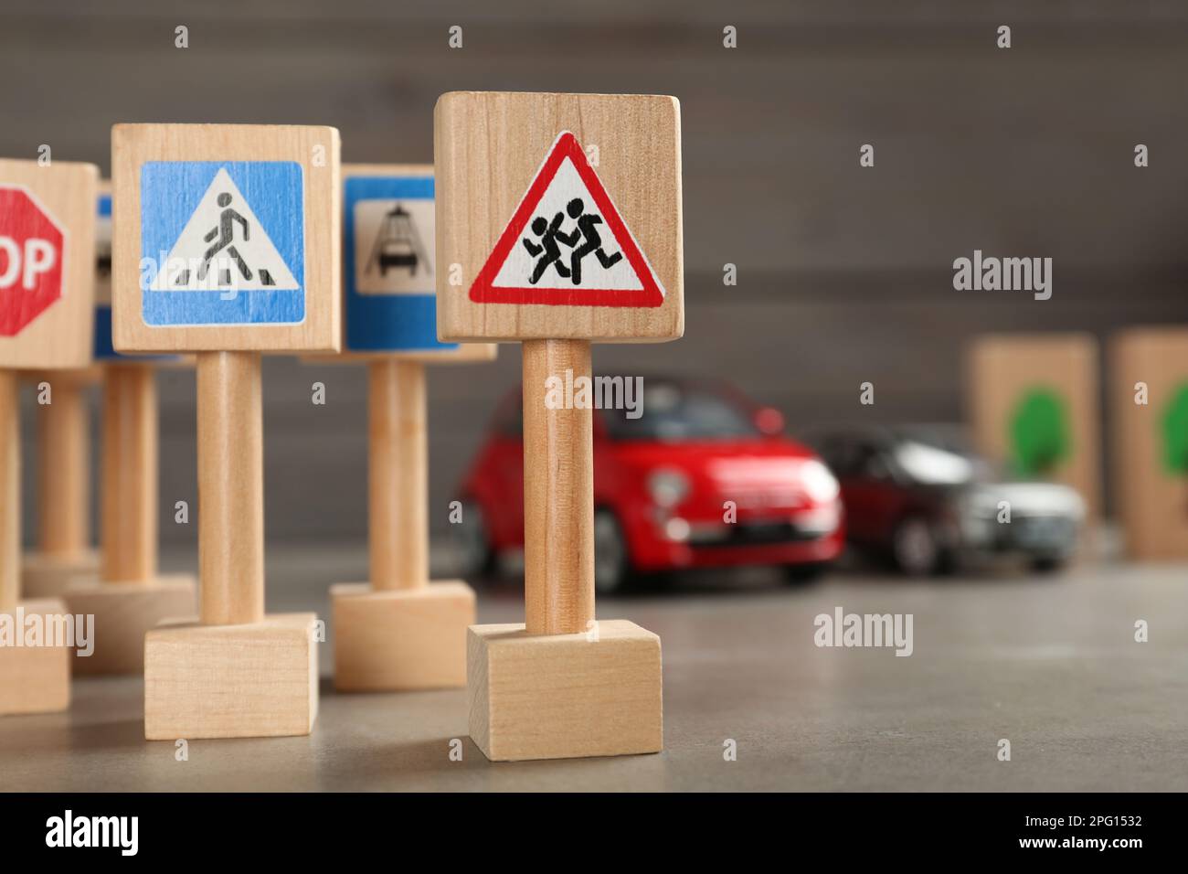 Many different miniature road signs on grey table, closeup with space ...
