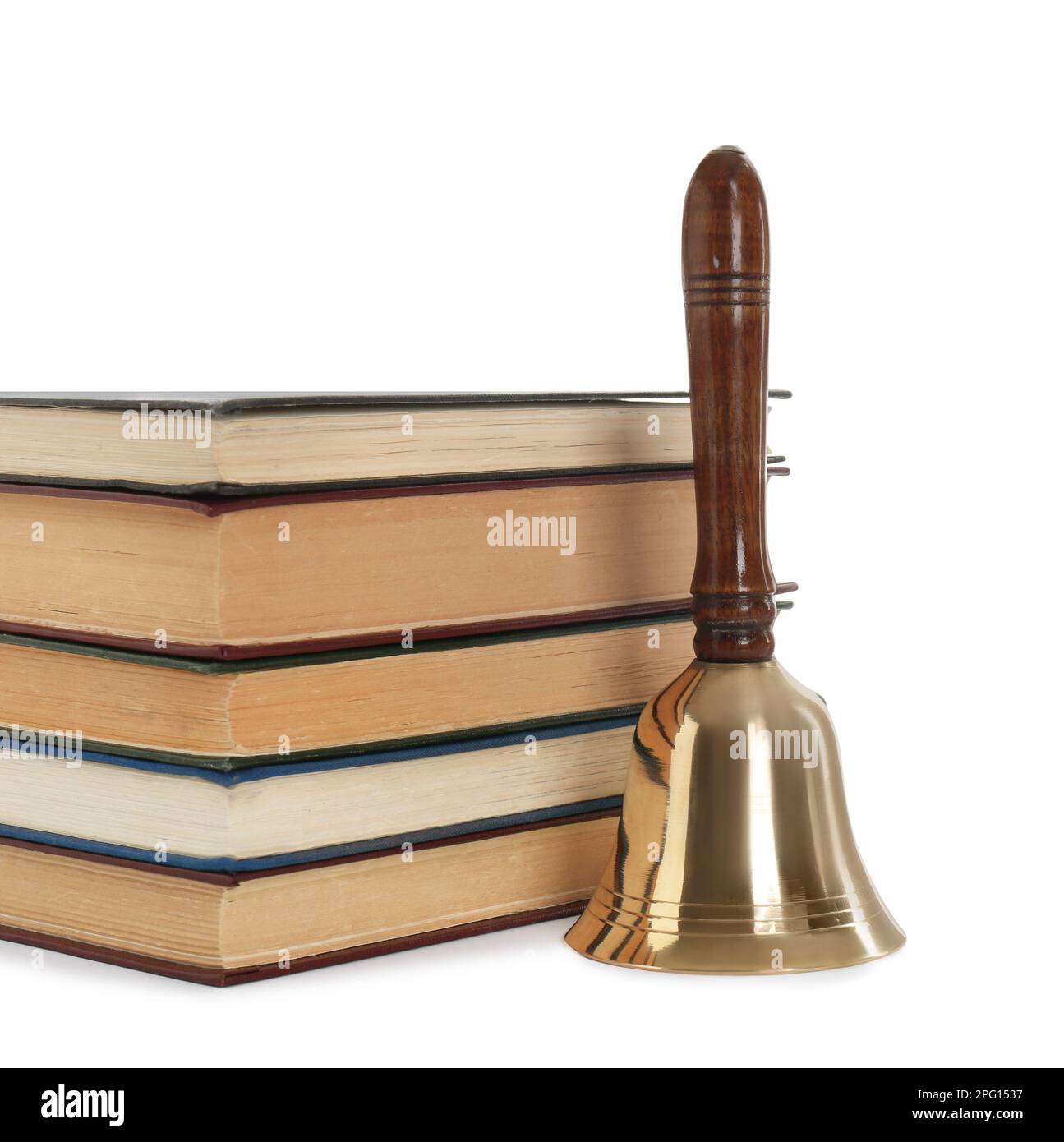 School bell with wooden handle and stack of books on white background ...