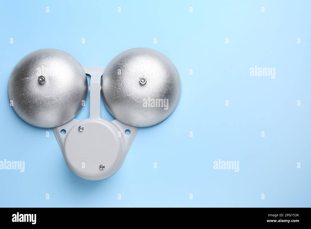 Modern electrical school bell on light blue background, top view. Space ...