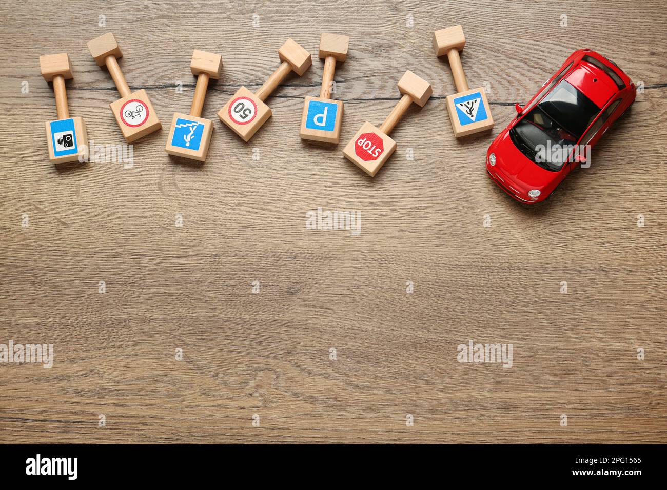Many different miniature road signs and car on wooden background, flat ...