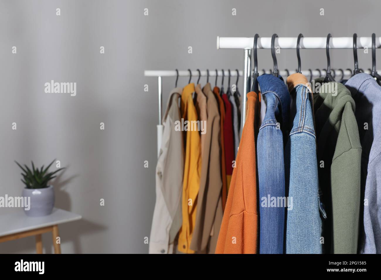 Racks with stylish clothes indoors. Fast fashion Stock Photo - Alamy