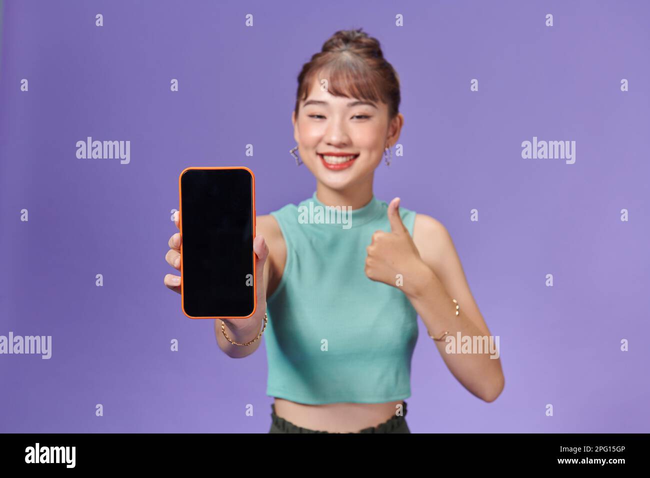 Portrait of smiling asian woman holding smartphone with black blank ...