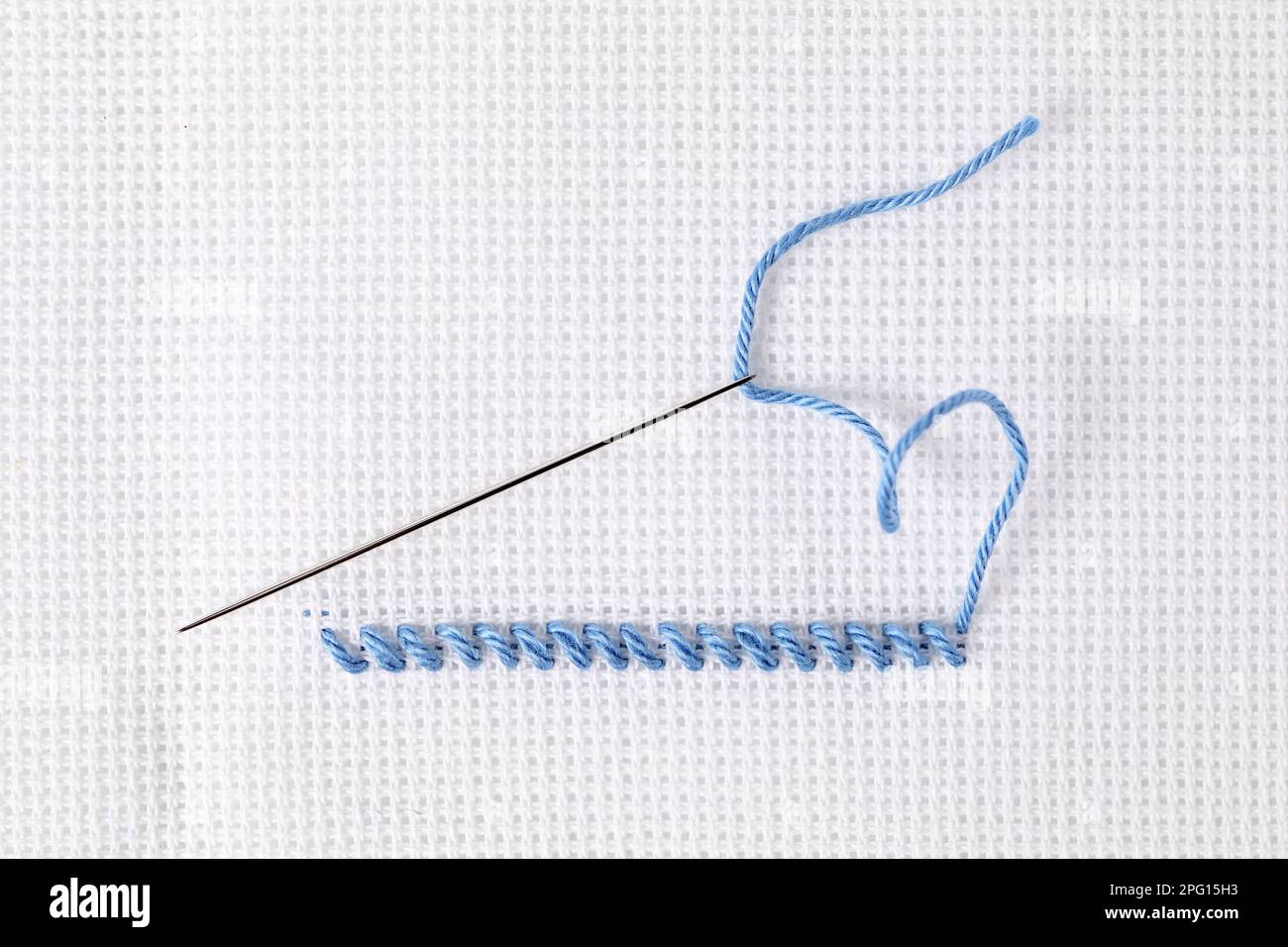 Canvas with embroidery thread and needle, top view Stock Photo - Alamy