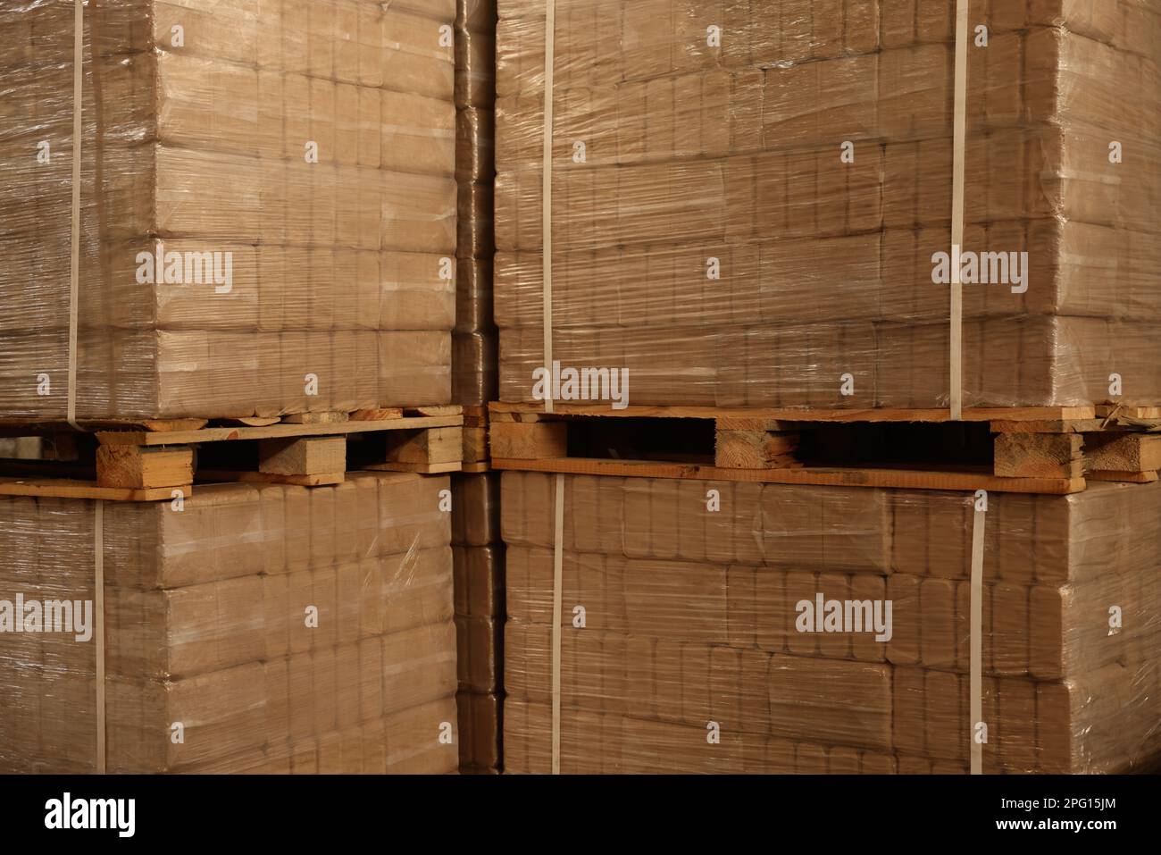 Stacks of merchandise wrapped in stretch film on wooden pallets Stock ...