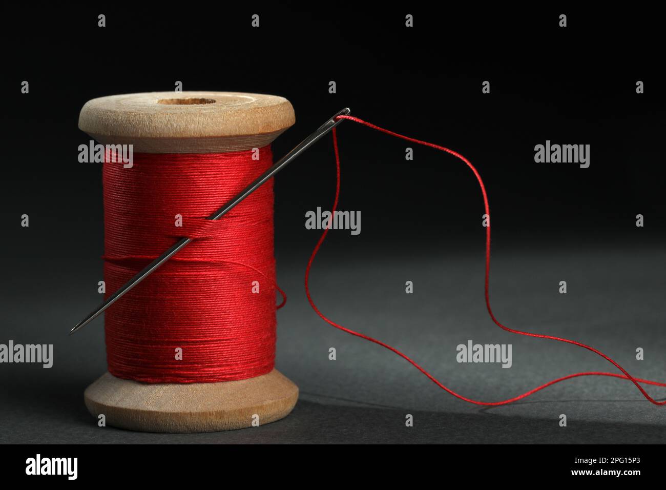 Red sewing thread with needle on black background, closeup Stock Photo ...