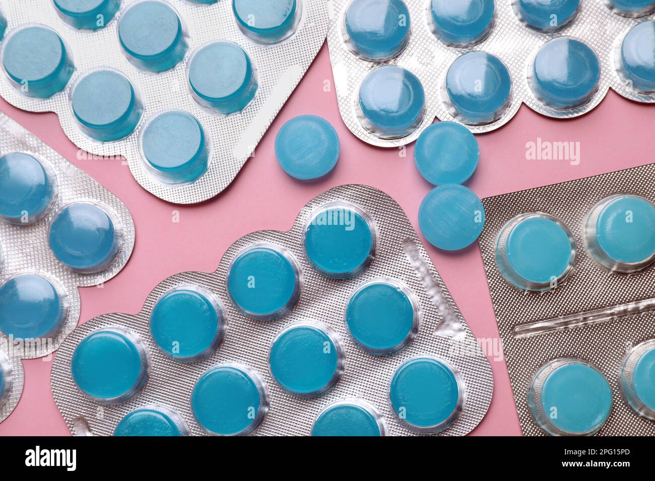 Blue cough drops on pink background, flat lay Stock Photo - Alamy