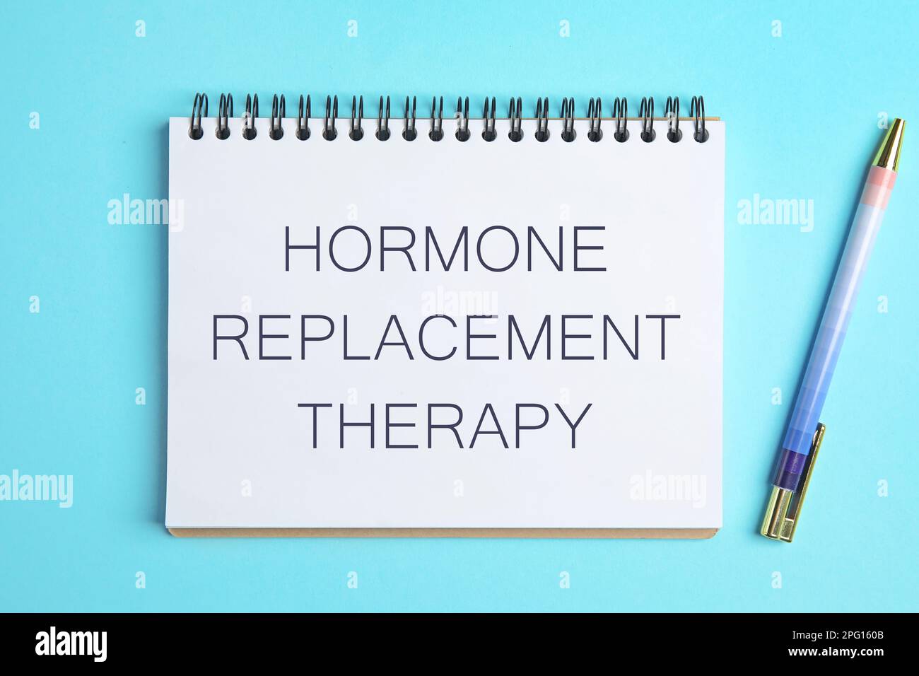Notebook with text Hormone Replacement Therapy and pen on turquoise ...