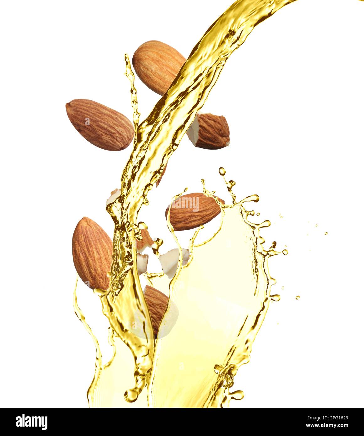 Organic almond oil and tasty nuts flying on white background Stock ...