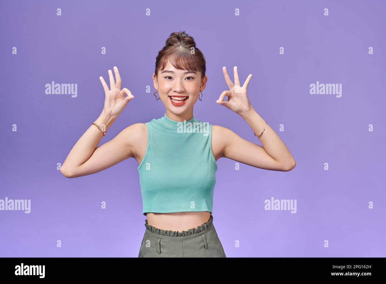 Cute woman with okay hand gesture isolated on purple background Stock ...