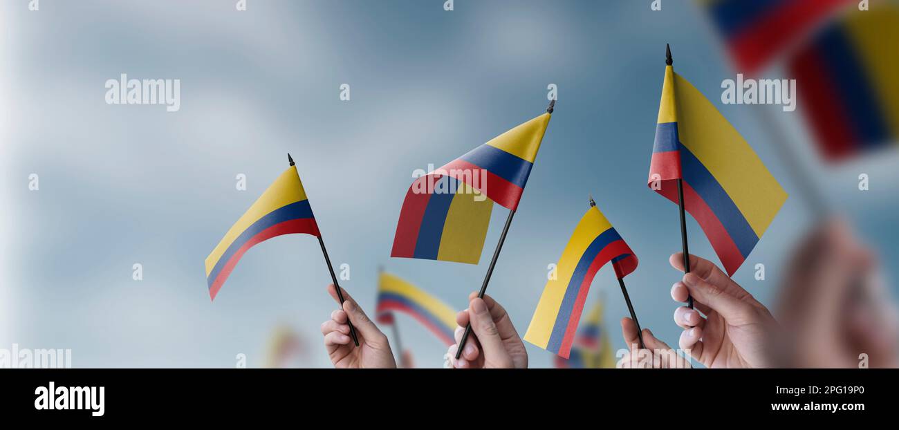 A group of people holding small flags of the Colombia in their hands ...
