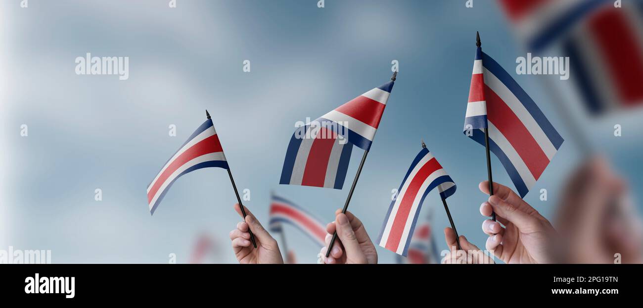 A group of people holding small flags of the Costa Rica in their hands ...