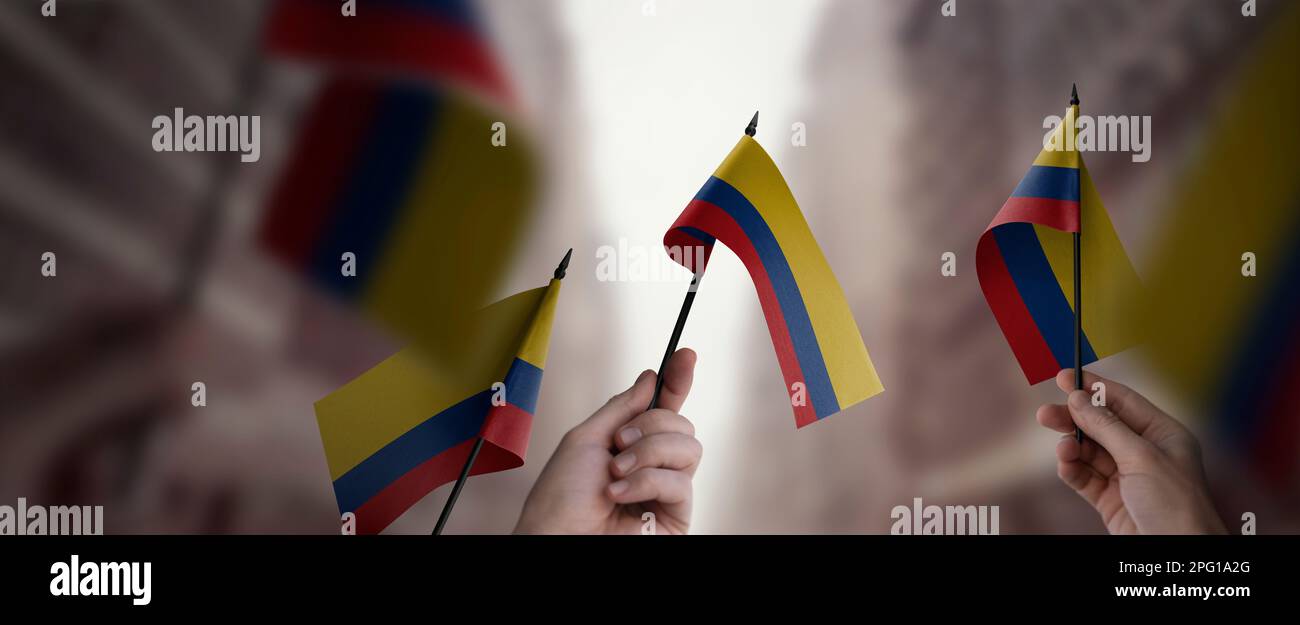 A group of people holding small flags of the Colombia in their hands ...