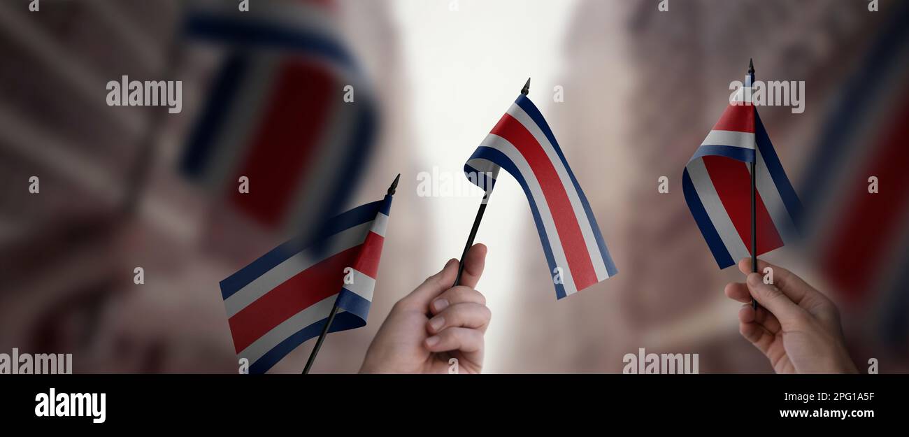 A group of people holding small flags of the Costa Rica in their hands ...