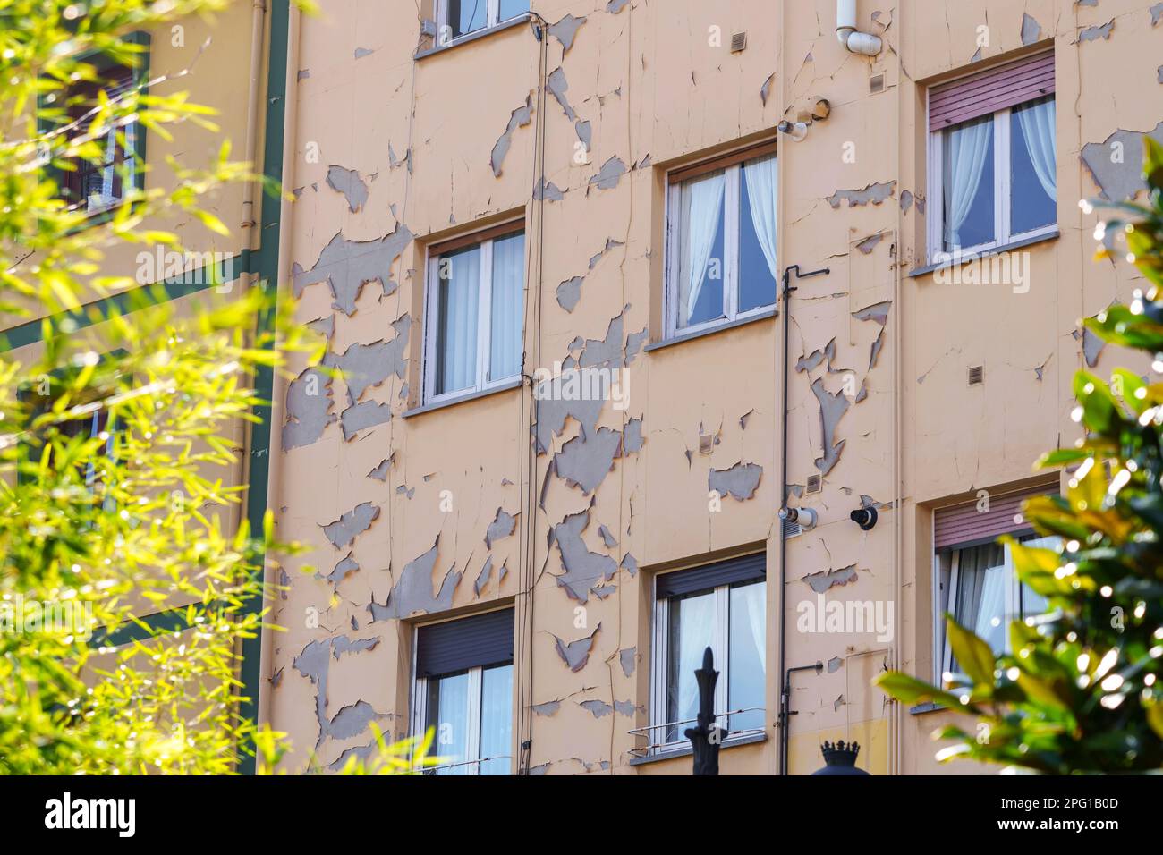 Damaged peeling paint on the wall of a residential building on a city ...